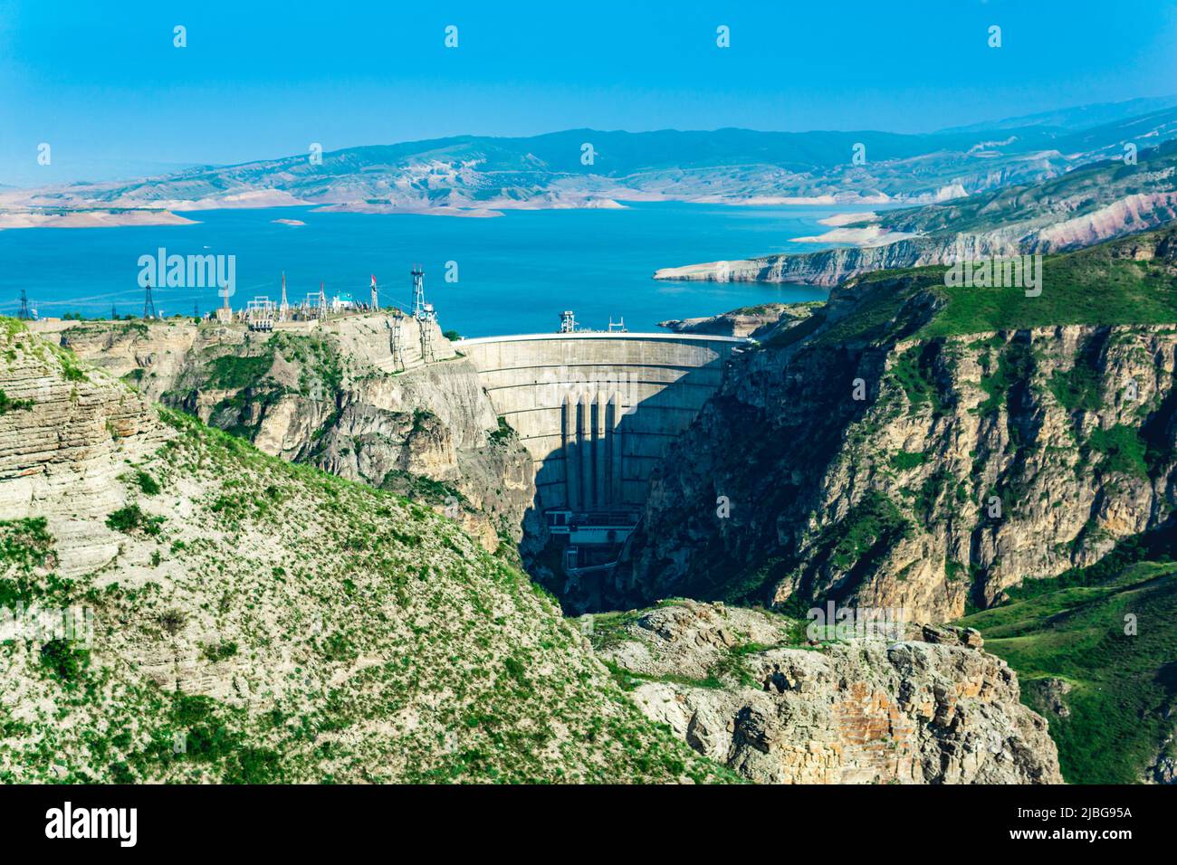 mountain landscape with an arched hydroelectric dam in the canyon and a ...