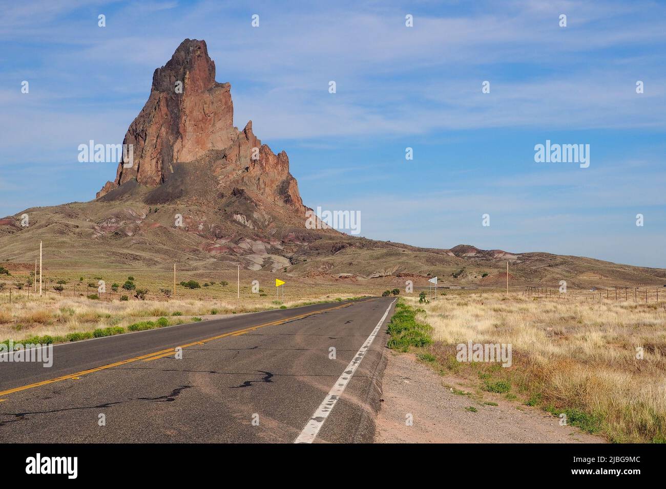 Asphalt road leading to a rock formation in the desert of Monument ...