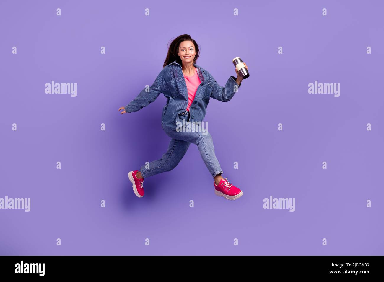 Full size portrait of cheerful pretty girl run rush jumping hold thermo ...