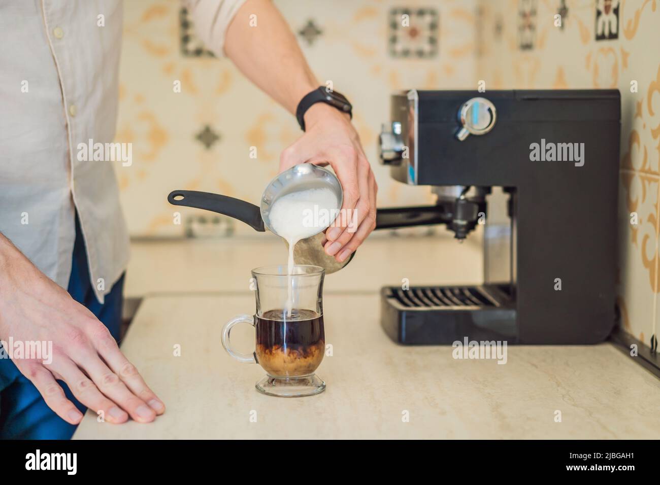 Handsome man using coffee machine in kitchen Stock Photo - Alamy