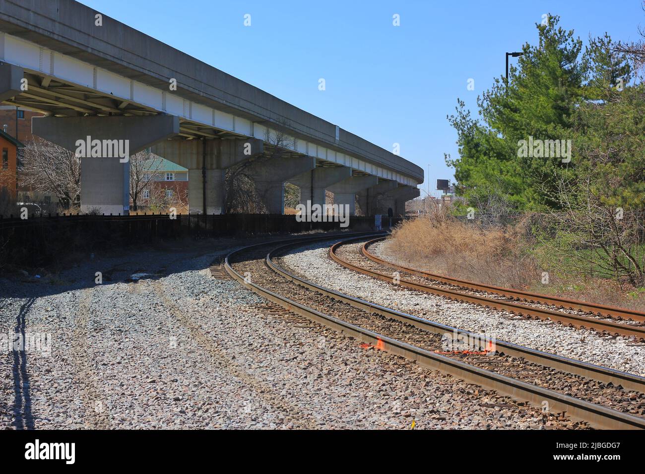Railroad tracks going into the distance under a bridge Stock Photo - Alamy