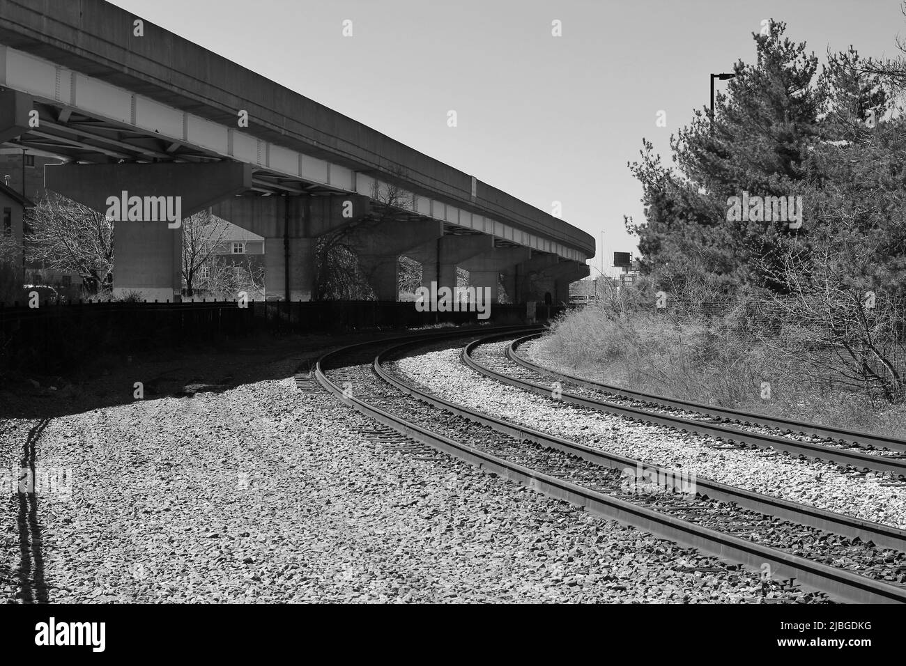Railroad tracks going into the distance under a bridge in black and ...