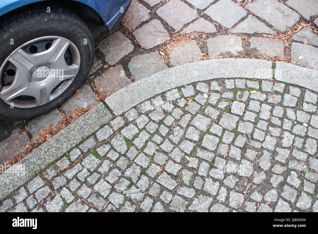 The image of arched stone pavement and parked car on the street in ...