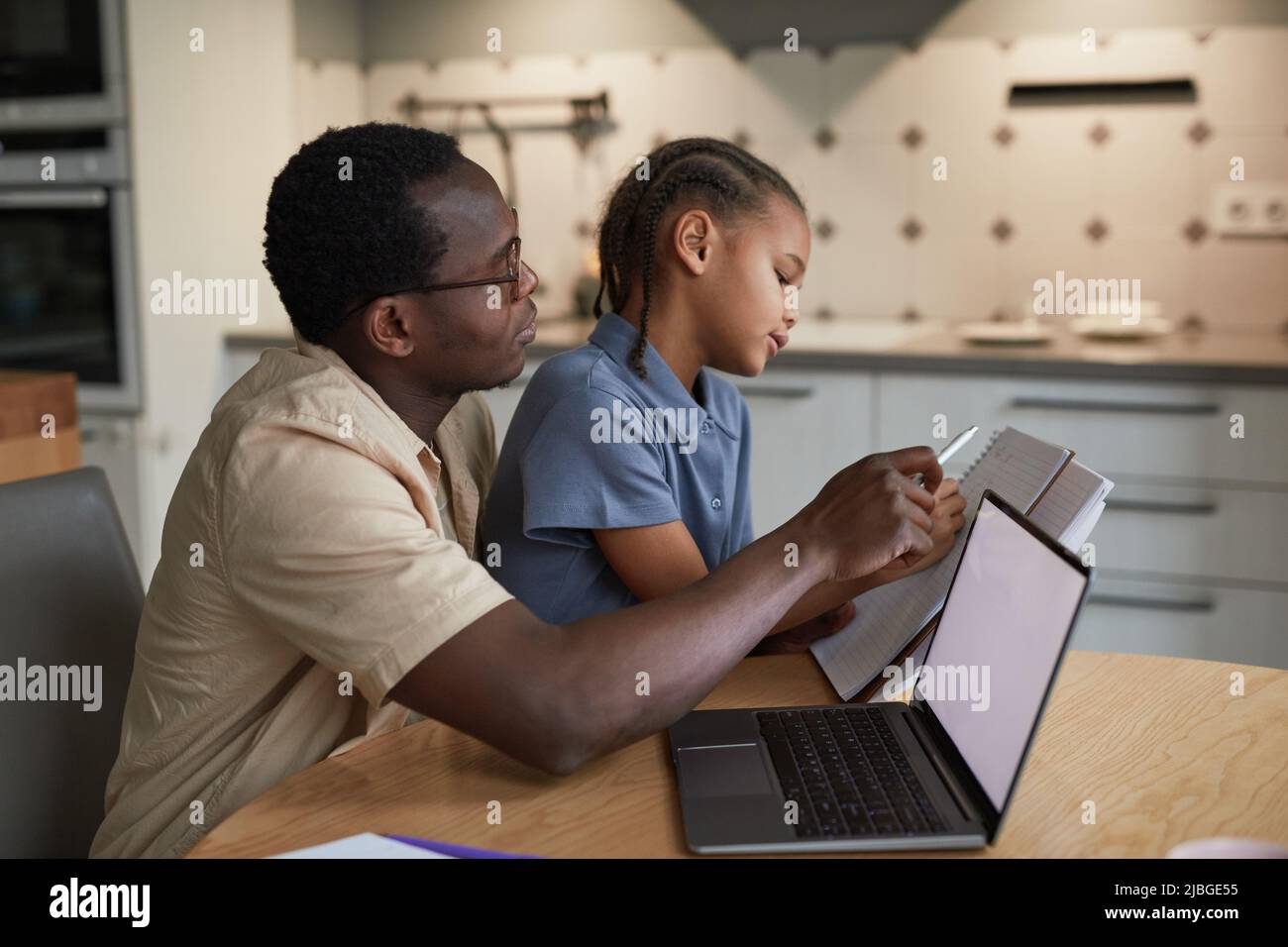 Side view portrait of caring black father helping daughter with ...