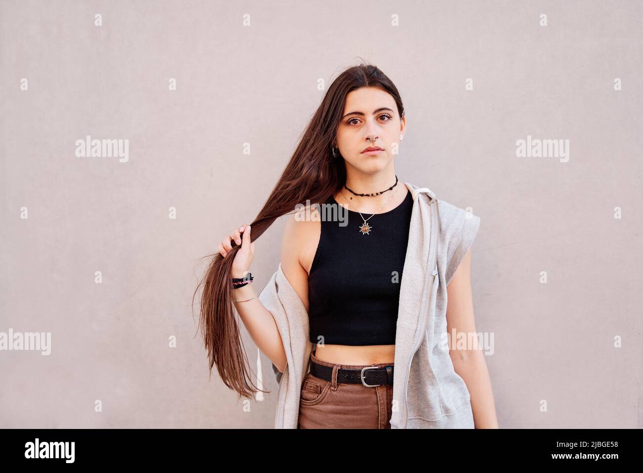 teenager posing while grabbing her long hair with her hand Stock Photo ...