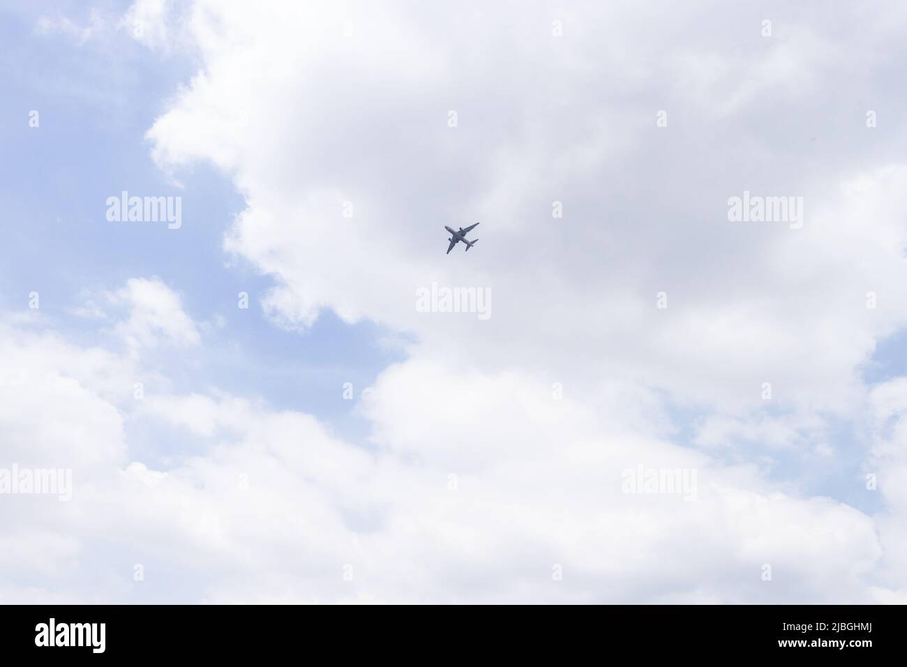 Airplane in air on cloudy sky. View of flying airplane from ground ...