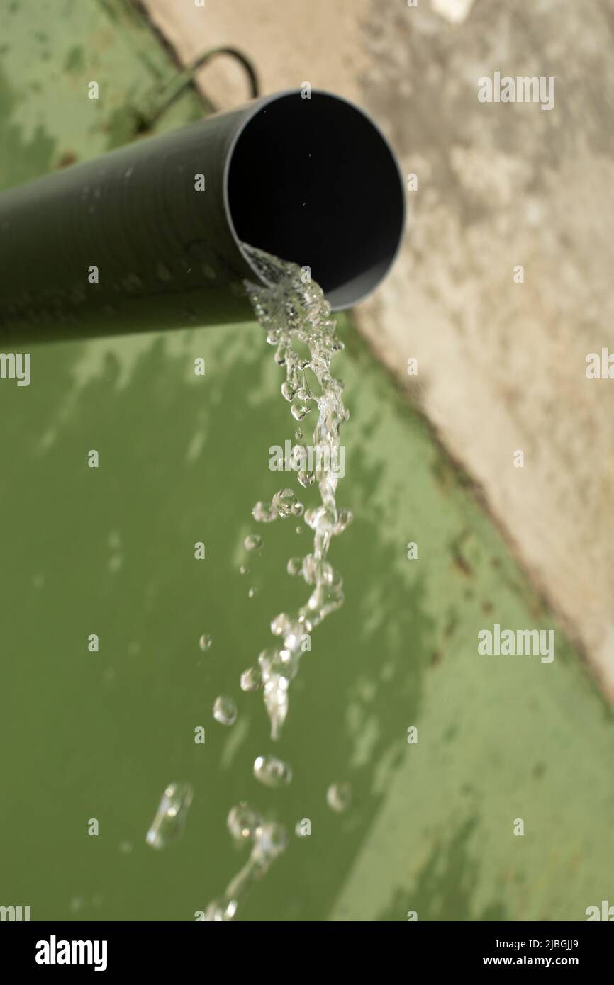 Water pours out of pipe. Details of building Stock Photo - Alamy