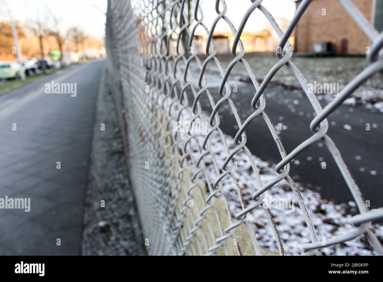 The close up of rusty wire fence with blurred background in winter ...