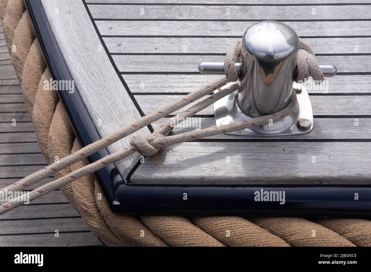 Stainless steel split bollard mooring cleat bit with ropes around it to ...