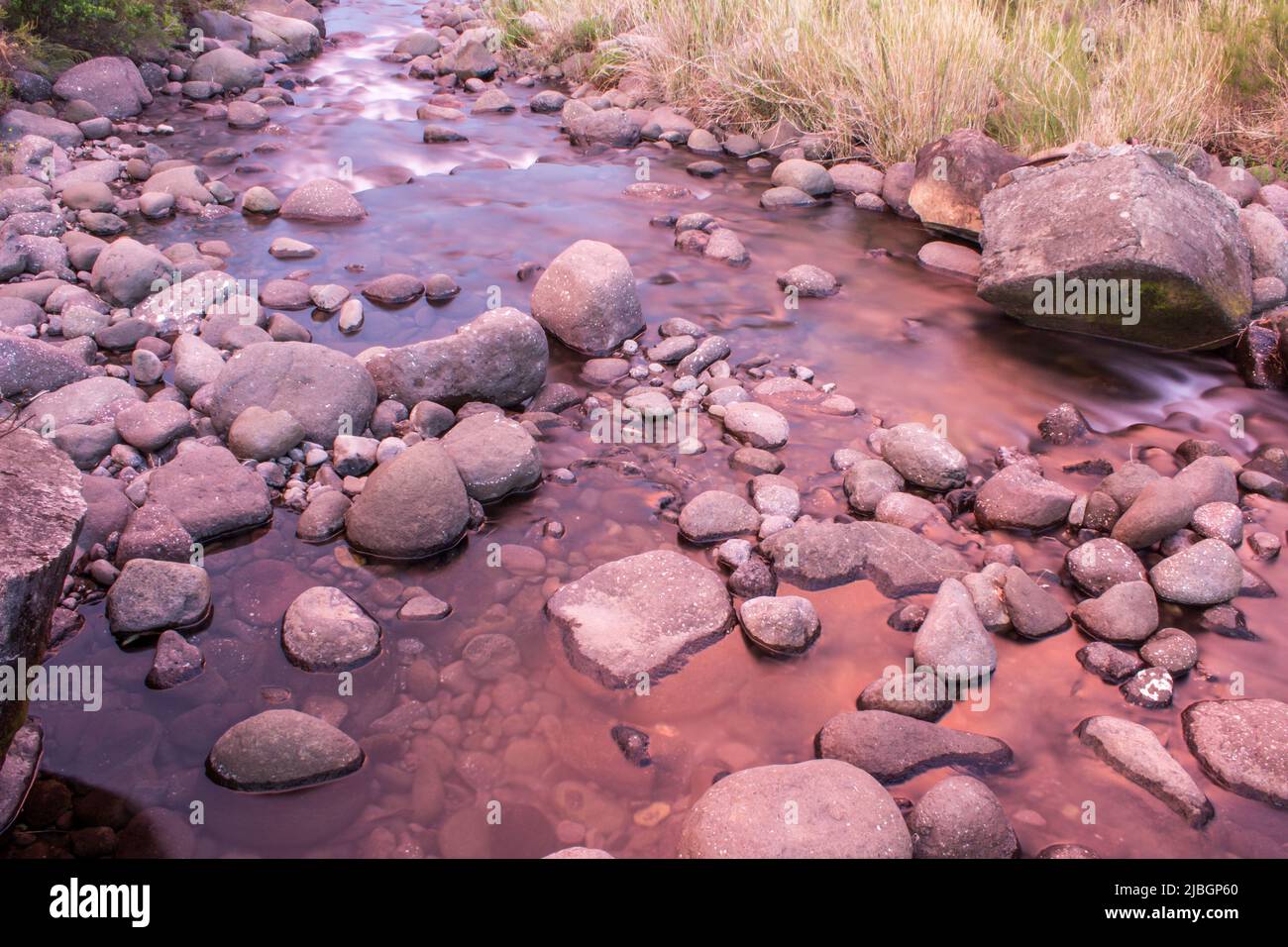 Copperish pink color of the setting sun, Reflecting in the fast flowing ...