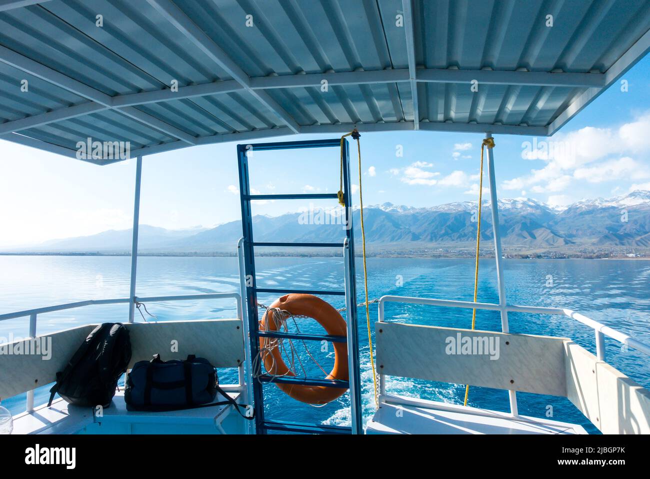 Ship's stern, lifeline. Footprint on the water from the boat. Blue ...