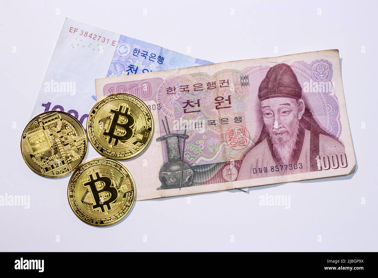 Close up of South Korean won (KRW) notes with bitcoins on white ...