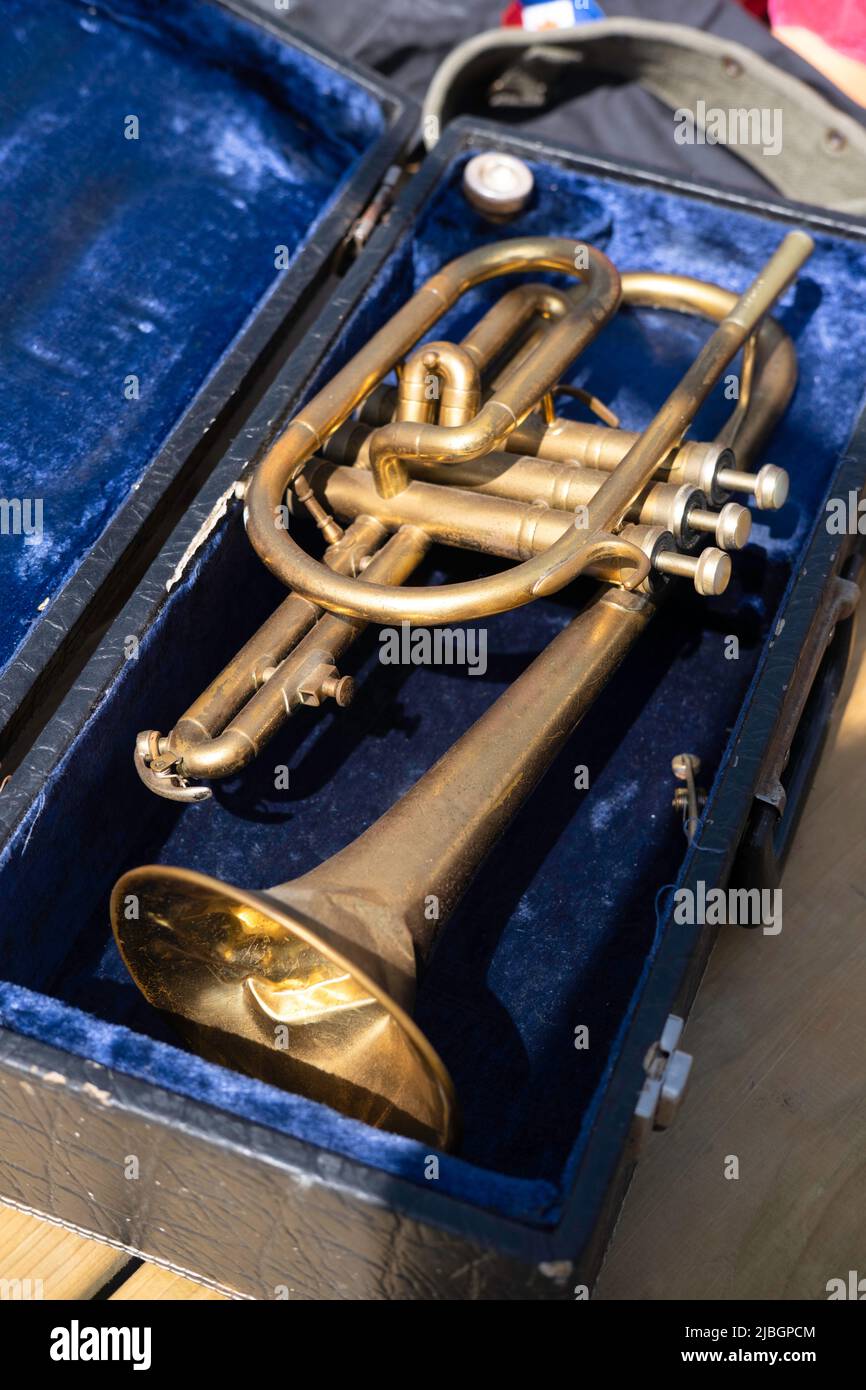 Copper-colored trumpet in a blue cloth-lined case is for sale at a flea ...