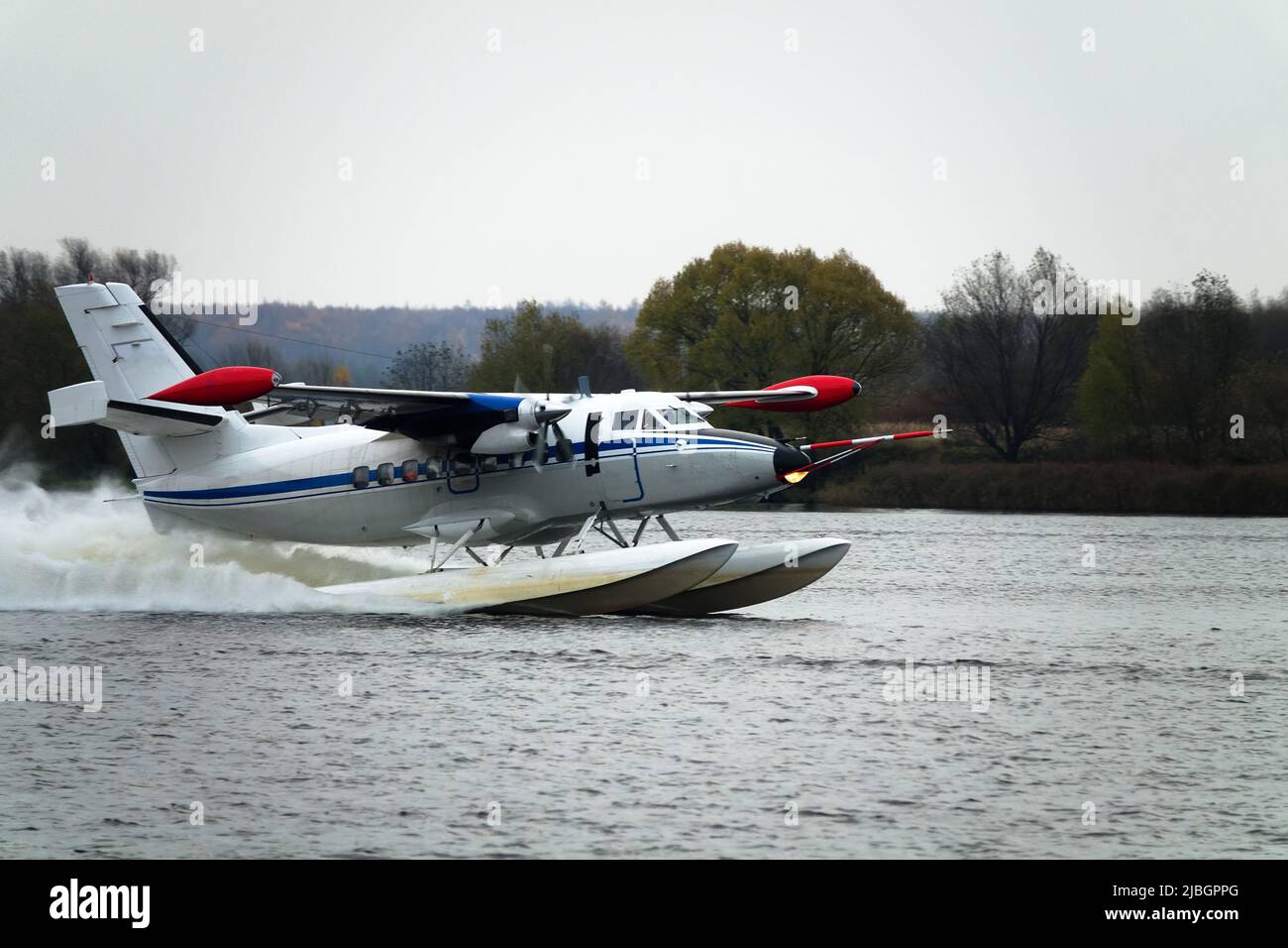 The Twin-engine seaplane a seaplane rises from water, from the forest ...