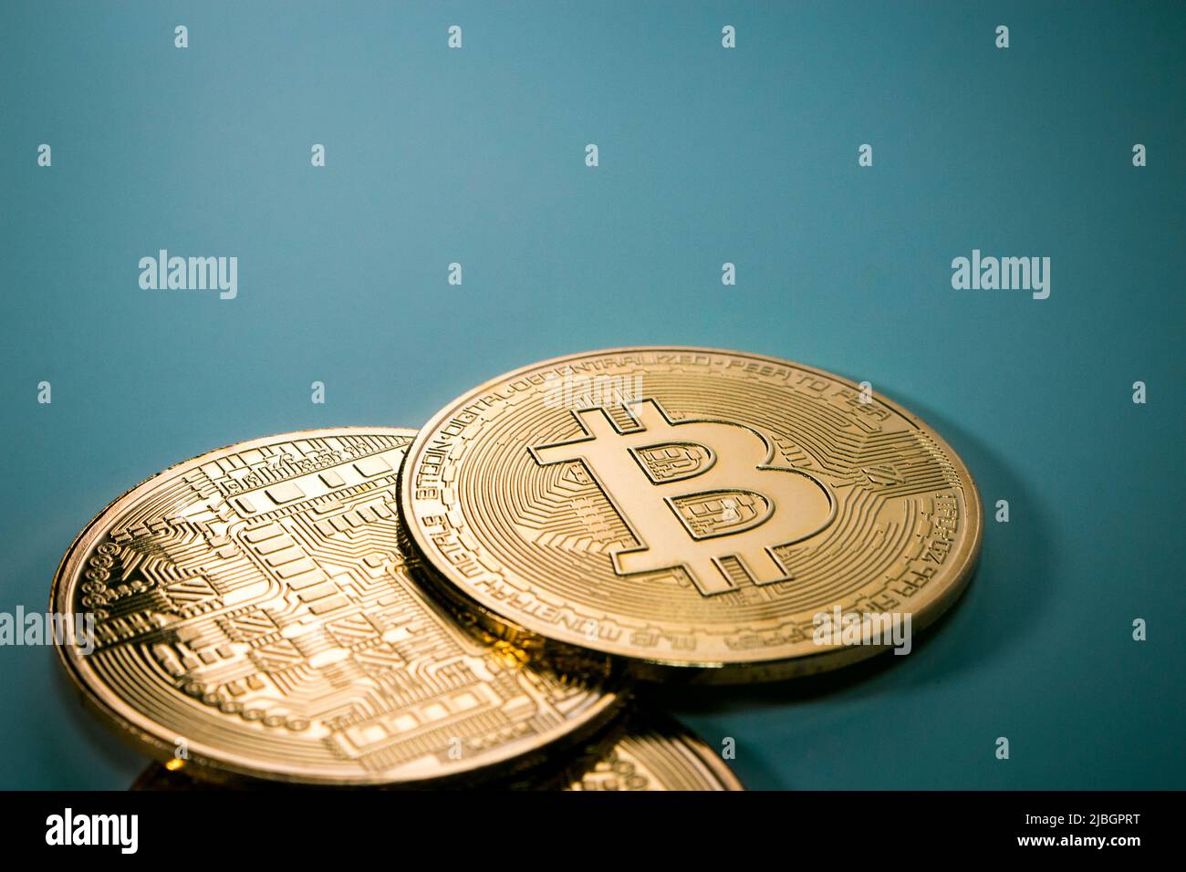 The close up of three gold Bitcoins in plain background Stock Photo - Alamy