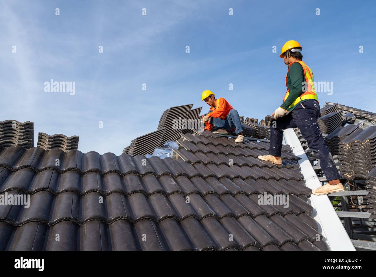 Teamwork of 2 Roofers worker in protective uniform wear and gloves ...