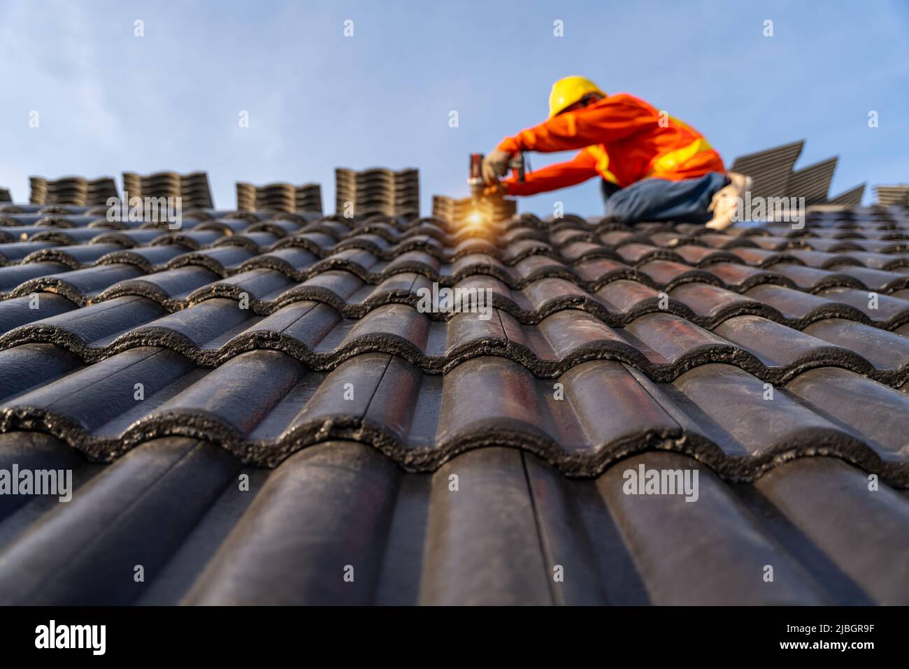 A Construction worker install new roof, Electric drill used on new ...