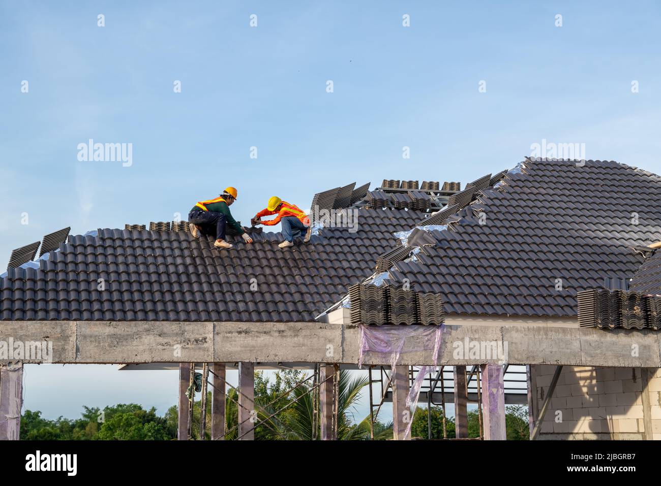 Teamwork of A Construction worker install new roof, Electric drill used ...