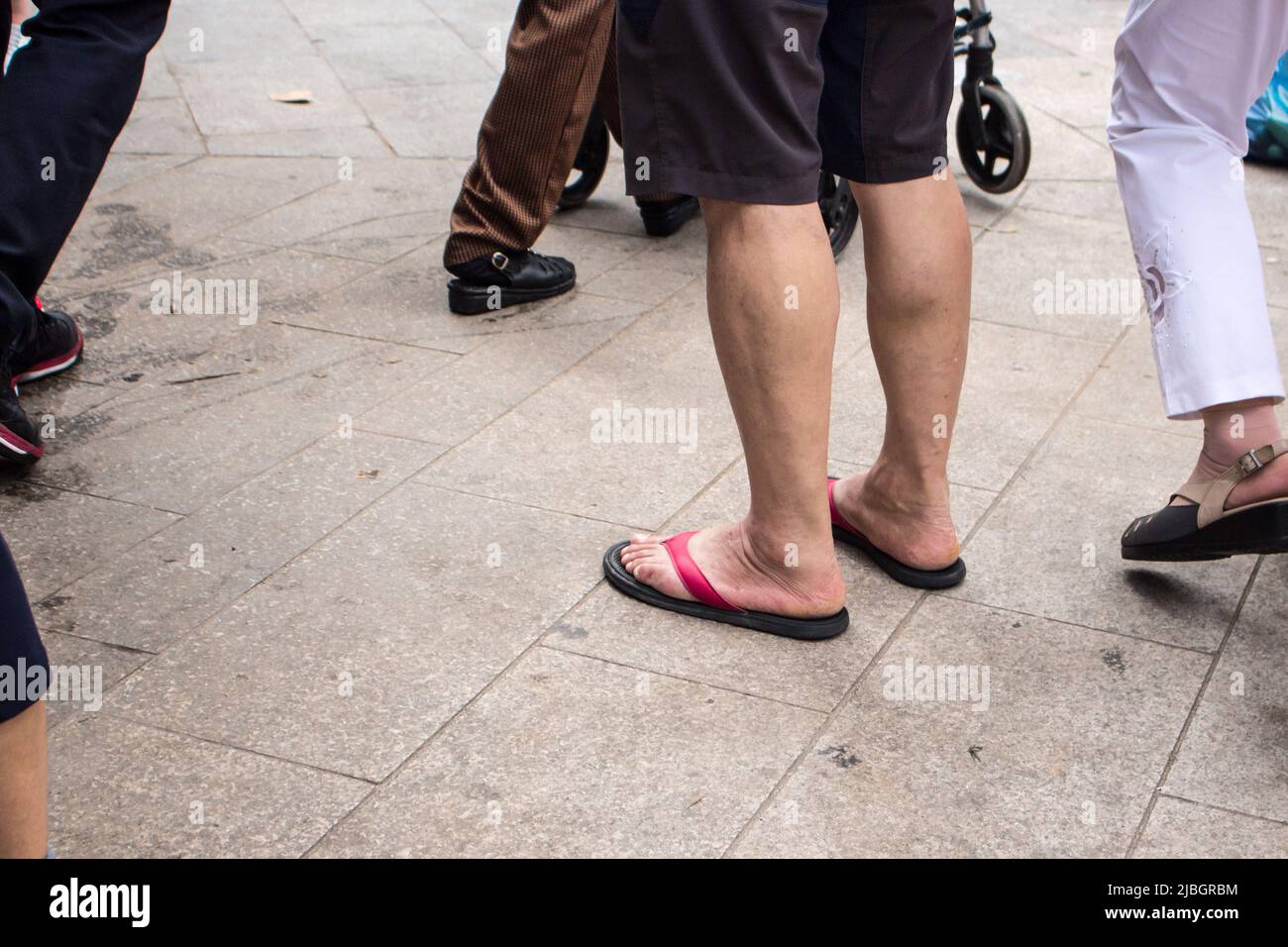 Close up of human feet with own shoes (or sandals) in crowd in downtown ...