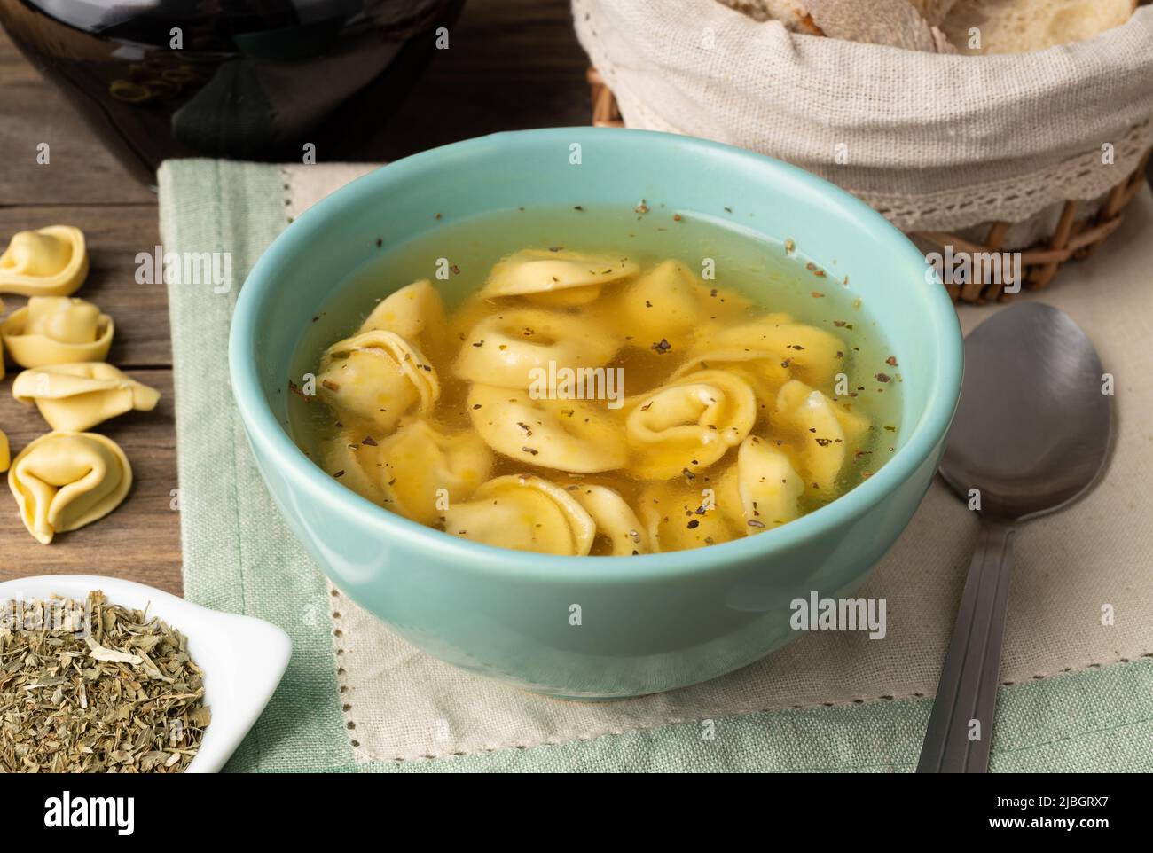Cappelletti or tortellini brodo soup in a bowl with bread slices and ...