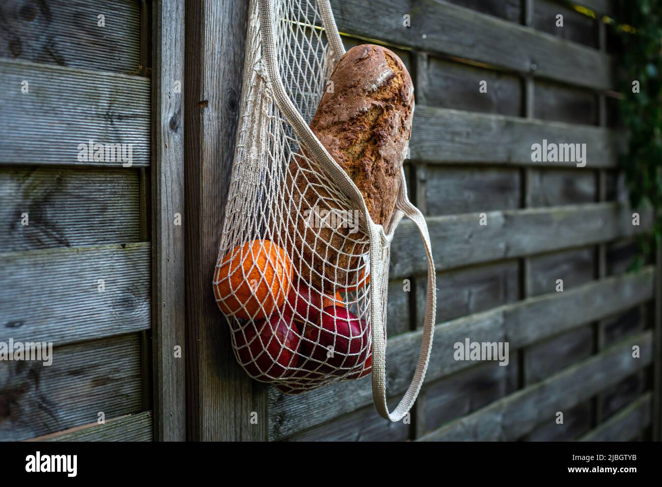 String bag with bread and fruits on a wooden background Stock Photo - Alamy