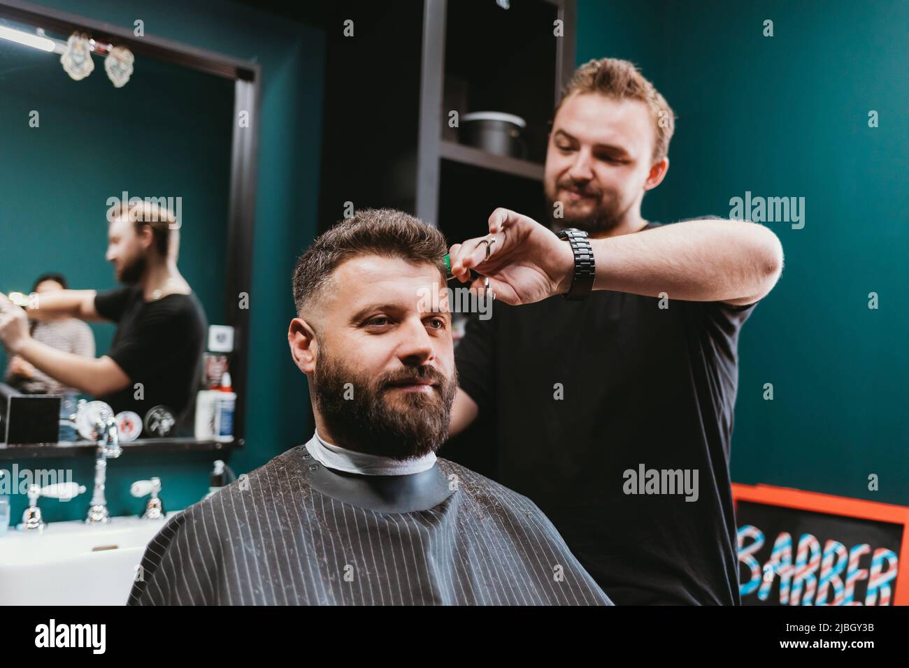 Barber doing hairstyle bearded man hi-res stock photography and images ...