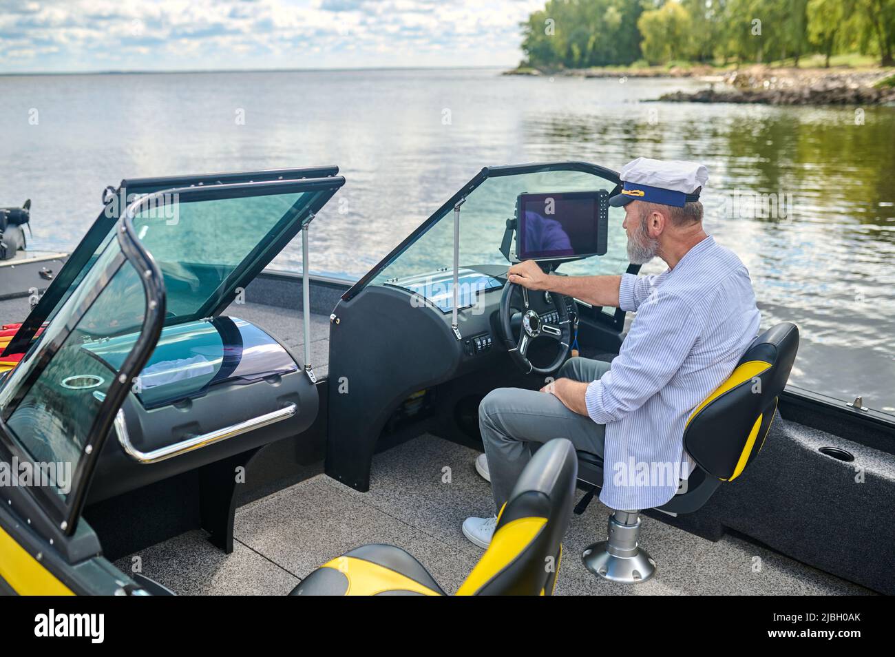 A man in a captains cap getting the boat ready Stock Photo - Alamy