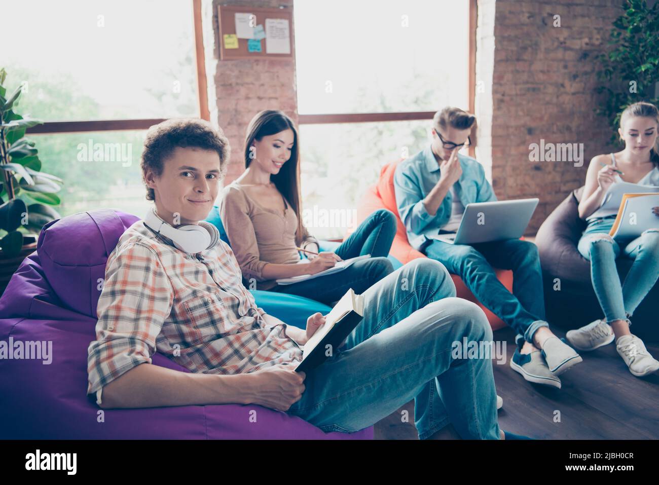 Photo of charming cute workers group sitting dorm reading novel working ...