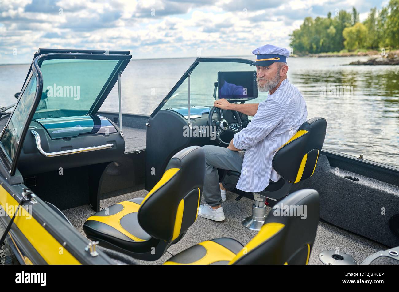 A man in a captains cap getting the boat ready Stock Photo - Alamy