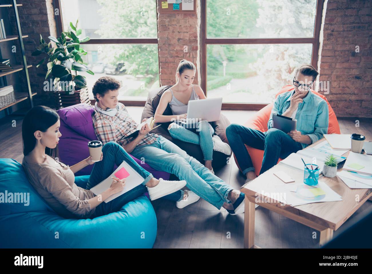Full length photo of four clever focused concentrated people sitting ...