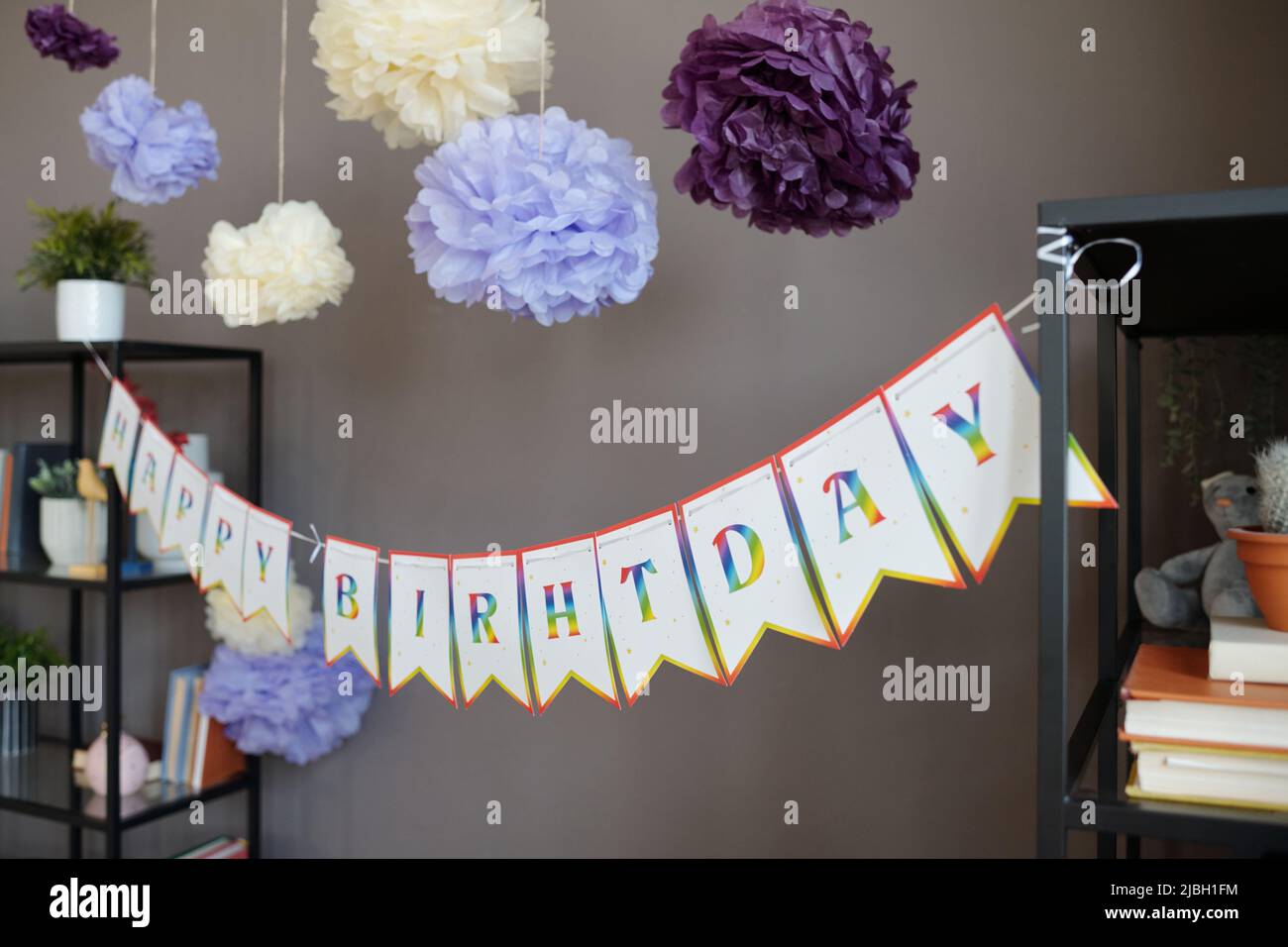 Image of banner with colored text Happy Birthday hanging on two shelves ...