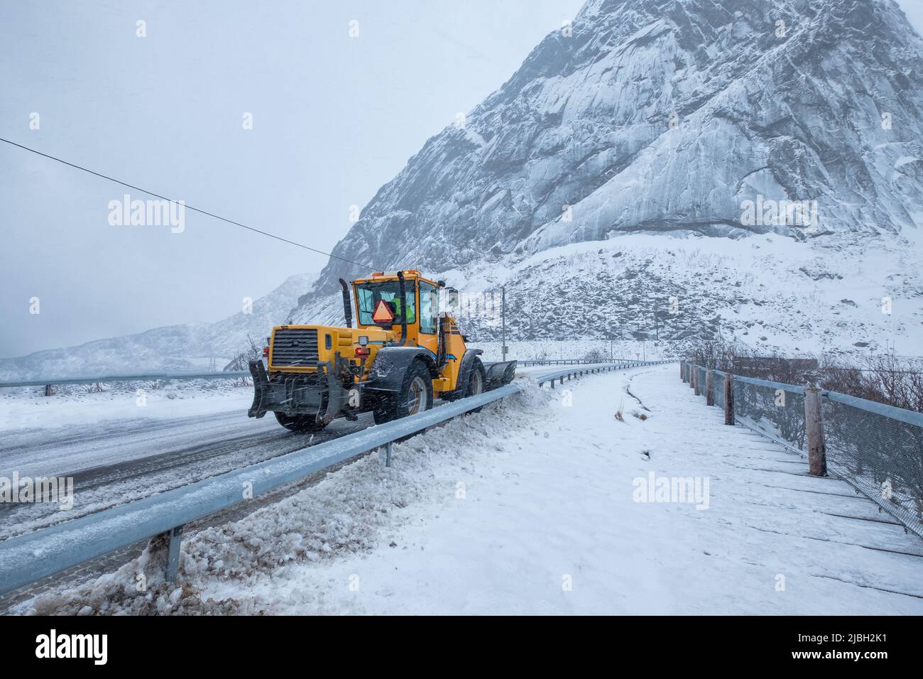 Snow ploughing truck cleaning snow on the road in suburban during heavy ...