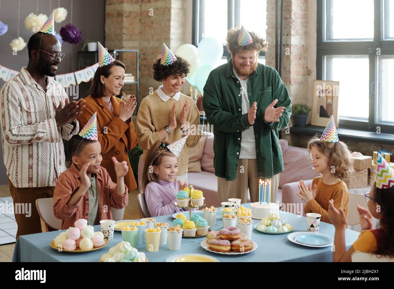 Parents and group of friends with children congratulating little boy ...