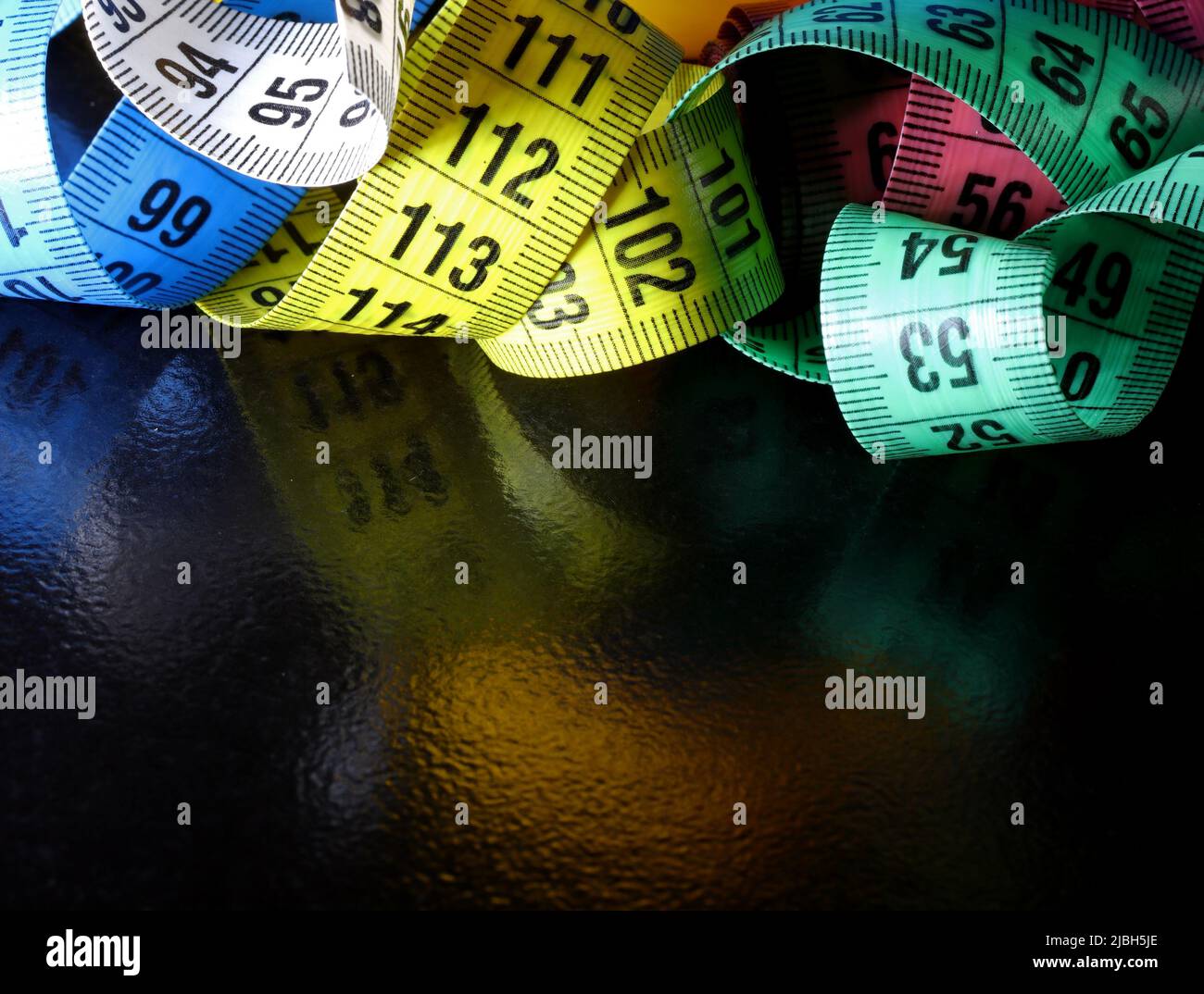 measuring tape on a black background Stock Photo - Alamy