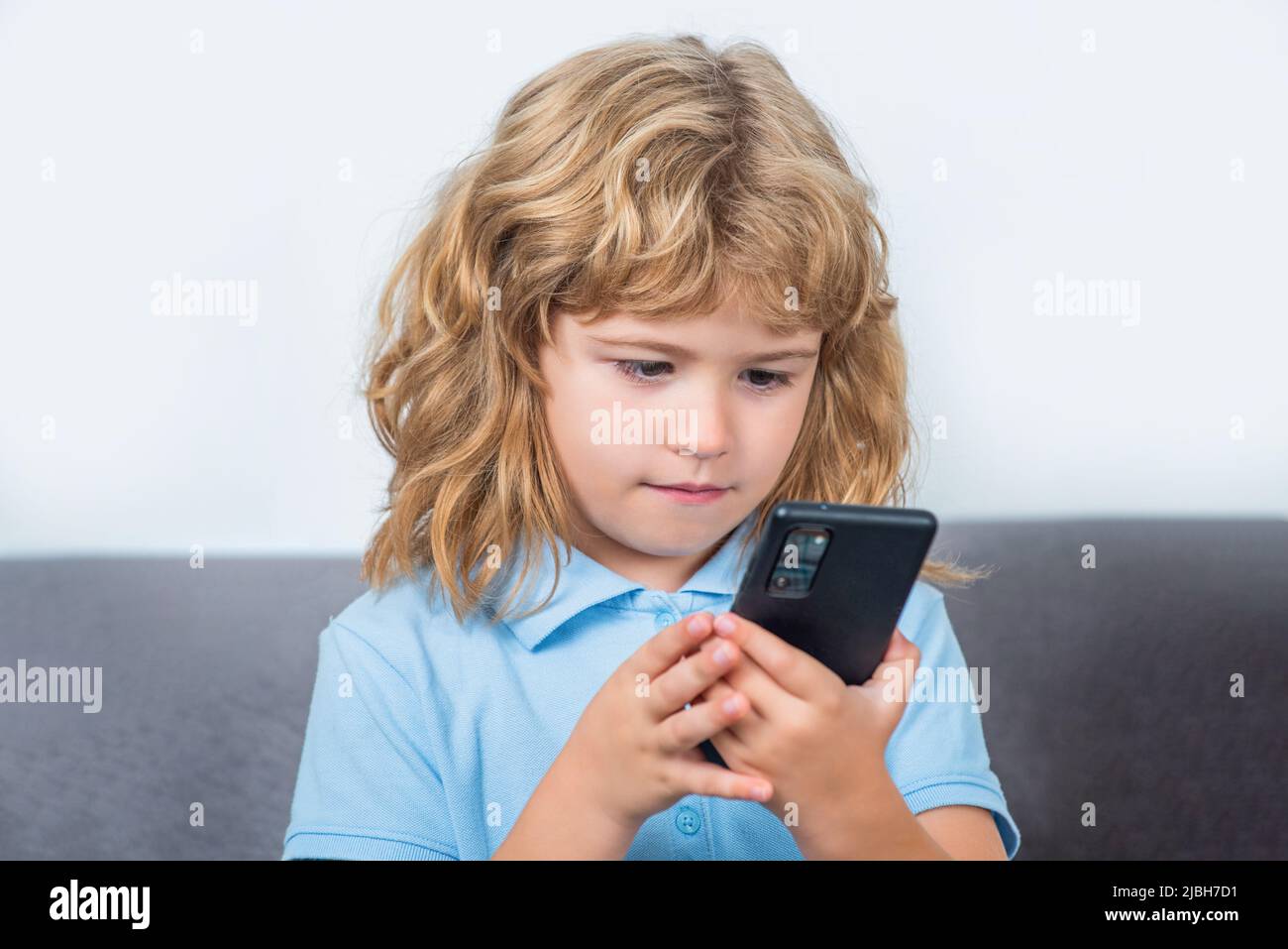 Little boy using smartphone, looking at screen, child holding phone in ...