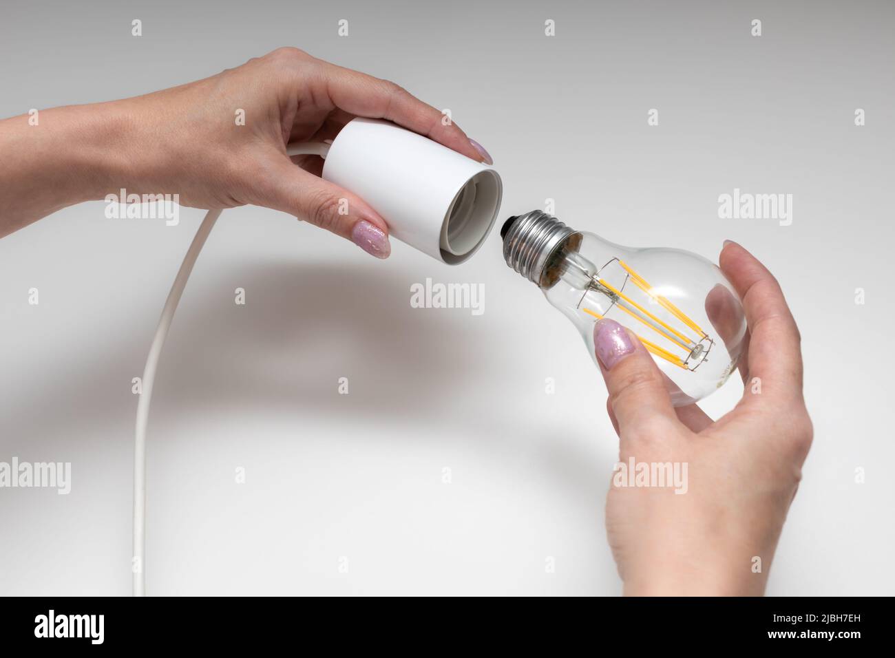 woman screwing a lamp into a socket Stock Photo - Alamy