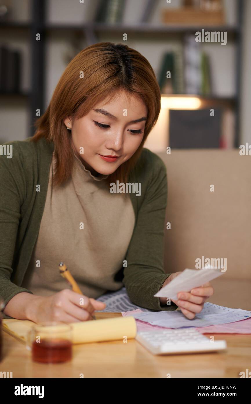 Young woman checking utility bills and receipts, managing monthly ...