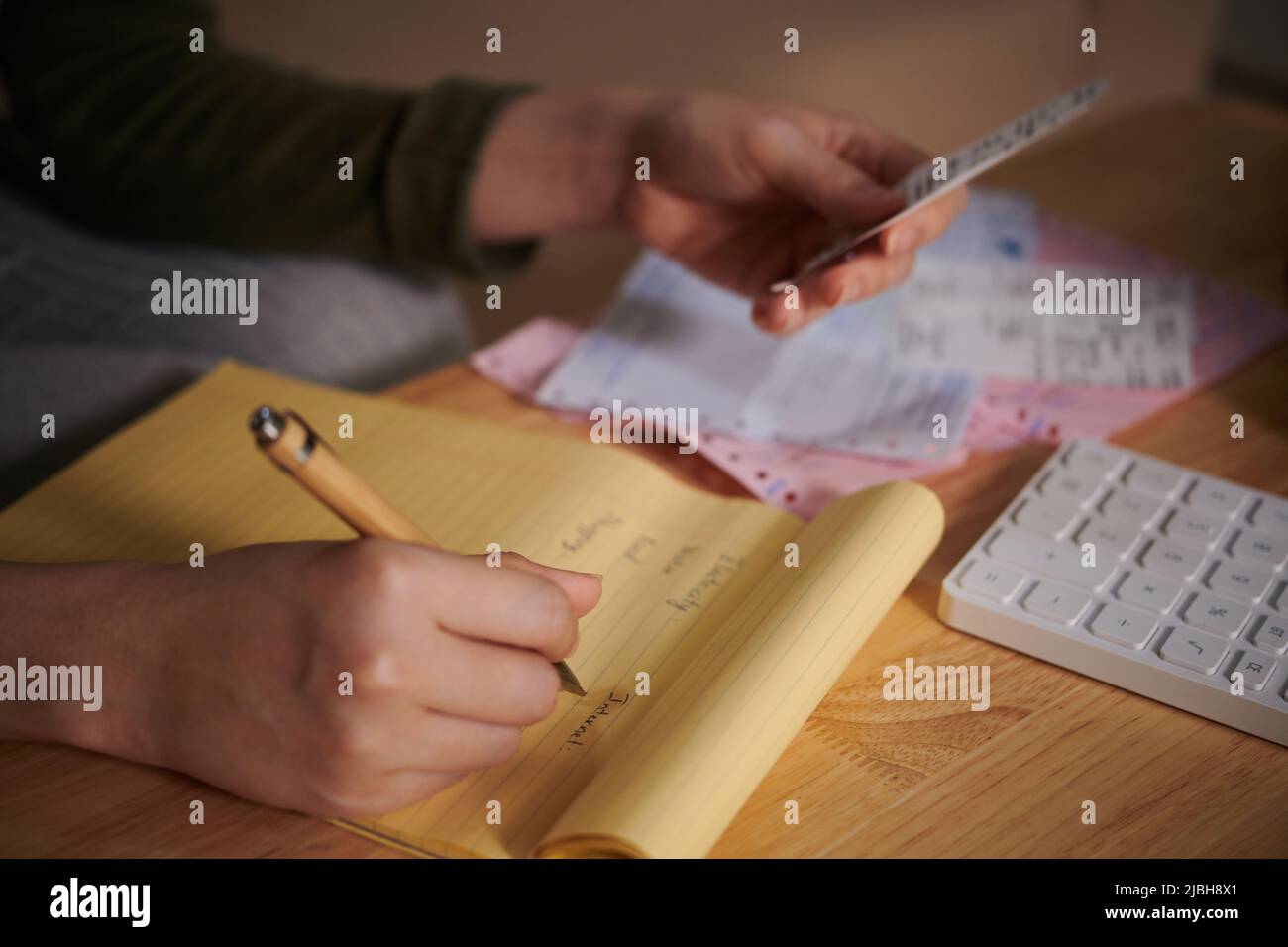 Hand of woman checking paychecks and planning her expenses in upcoming ...