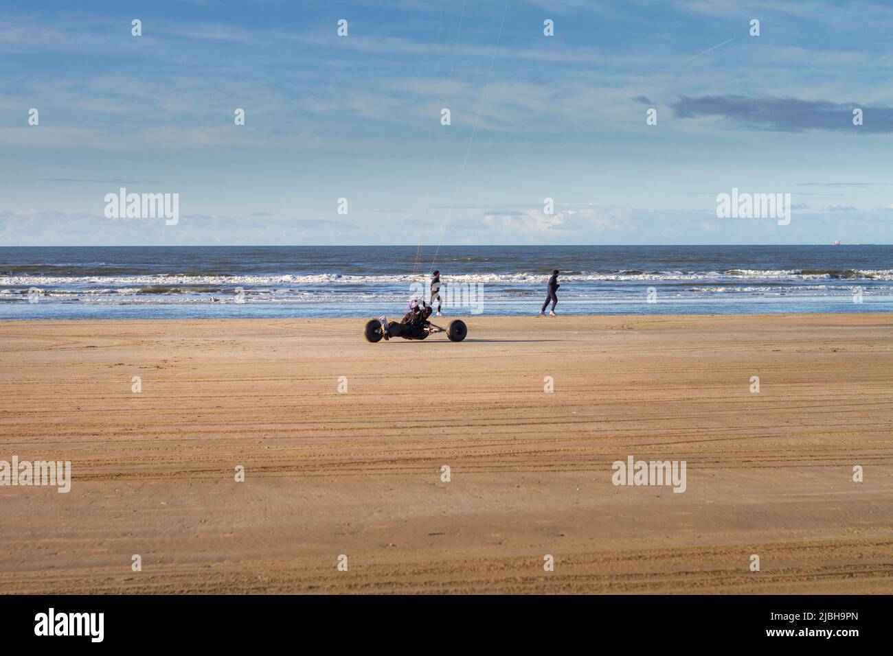 Man driving his three three wheeled vehicle attached to a parachute ...