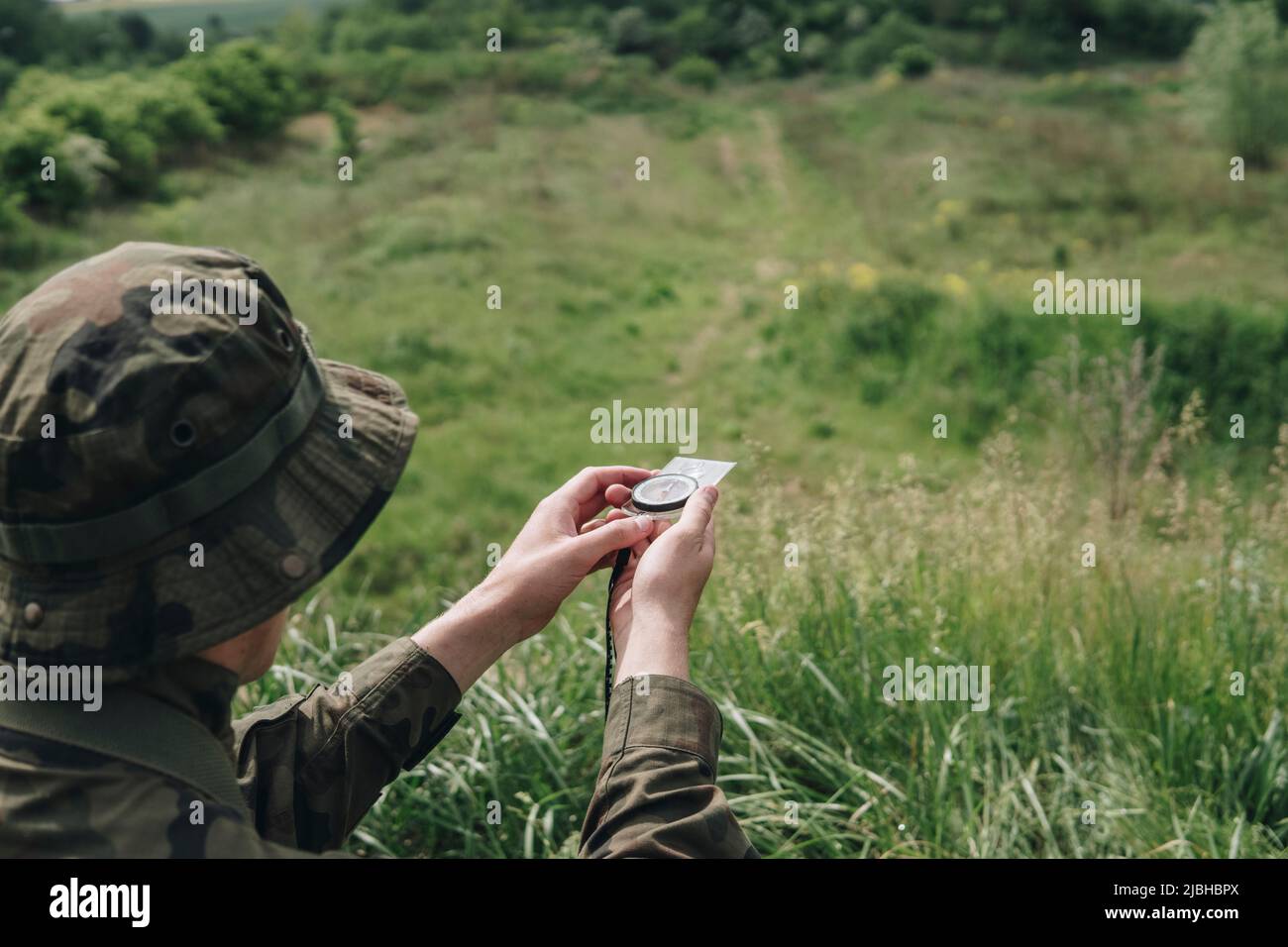 a young man in military outfit using a compass Stock Photo - Alamy