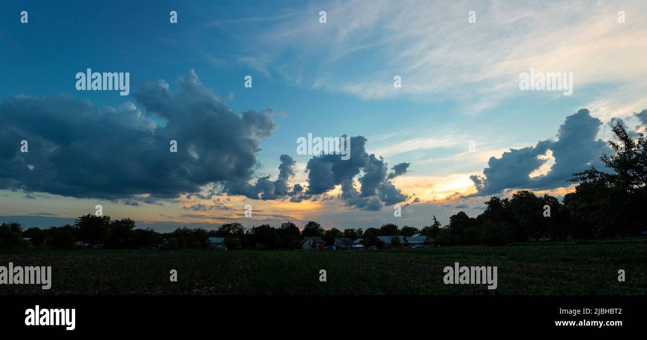 A real sunset sky with beautiful light clouds and sun rays, without ...
