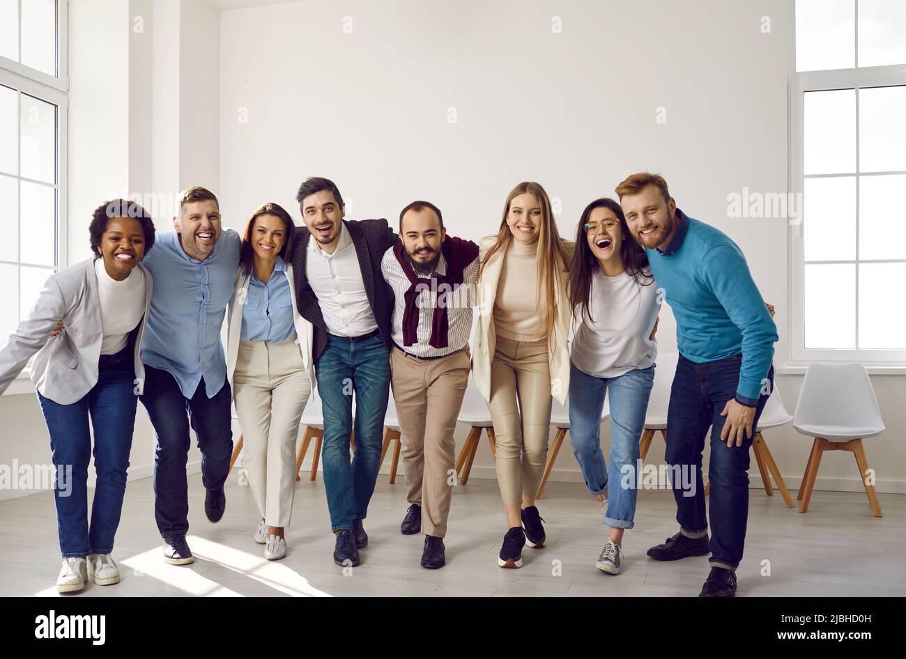 Diverse team of happy excited business people and friends having fun in ...