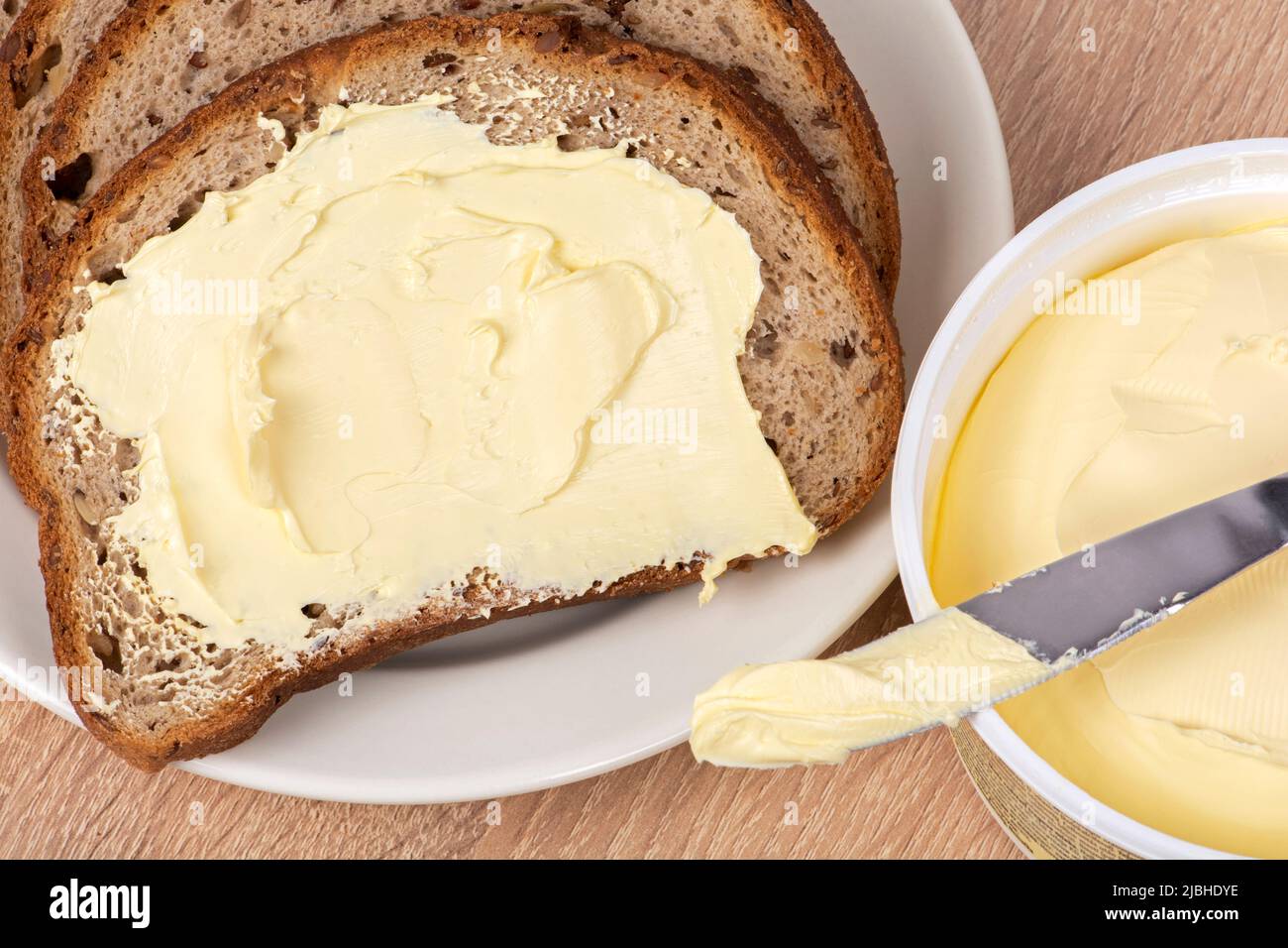 Bread and butter. A knife spreading butter on bread Stock Photo - Alamy
