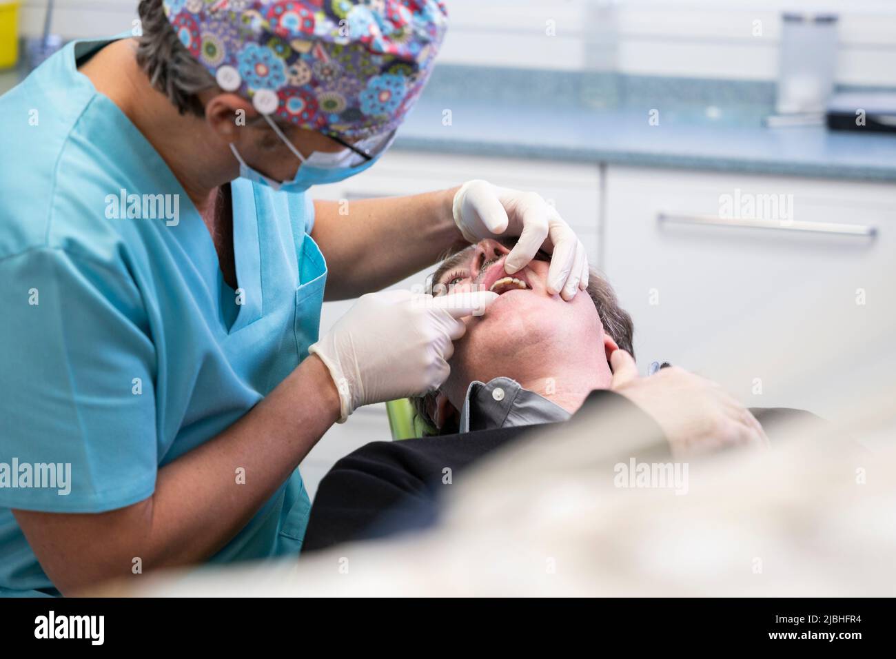 Dentist examining a patient in the clinic Stock Photo - Alamy