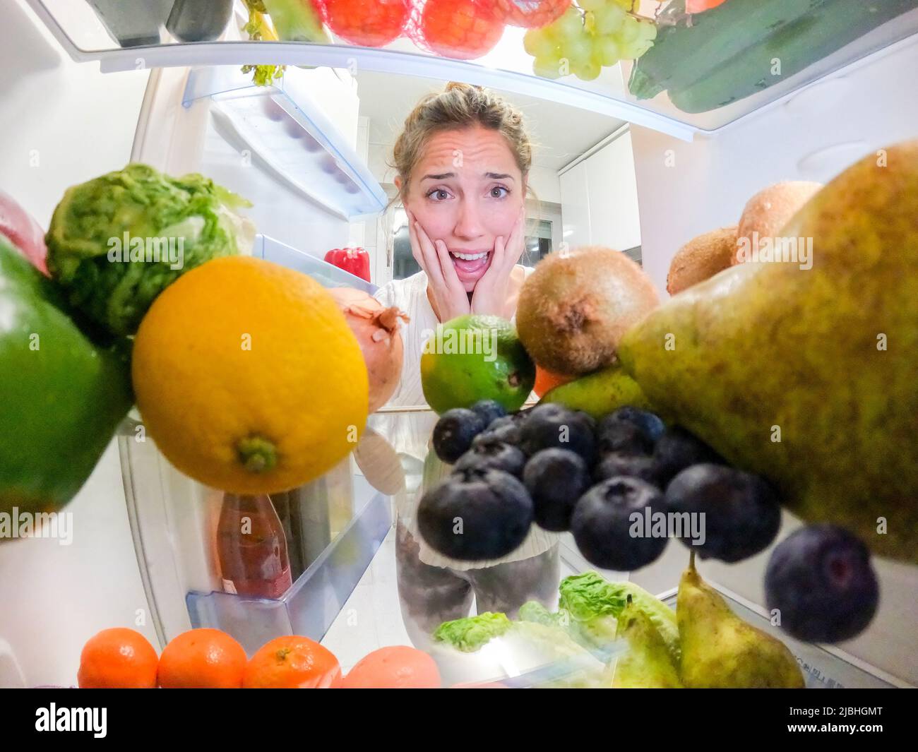 Young woman scared looking at healthy food inside the frigde Stock ...
