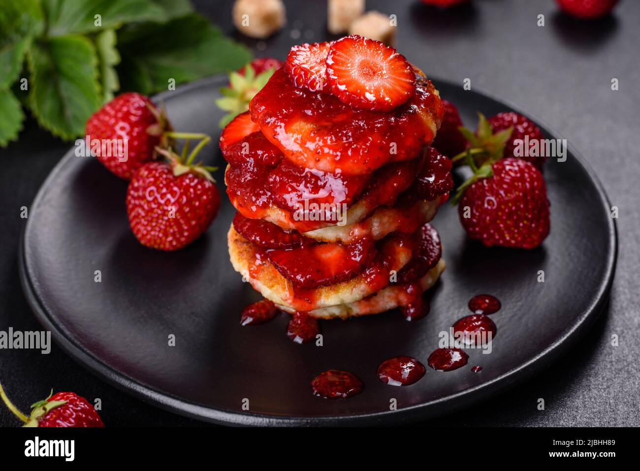 Cottage cheese pancake with strawberry jam on a concrete background ...