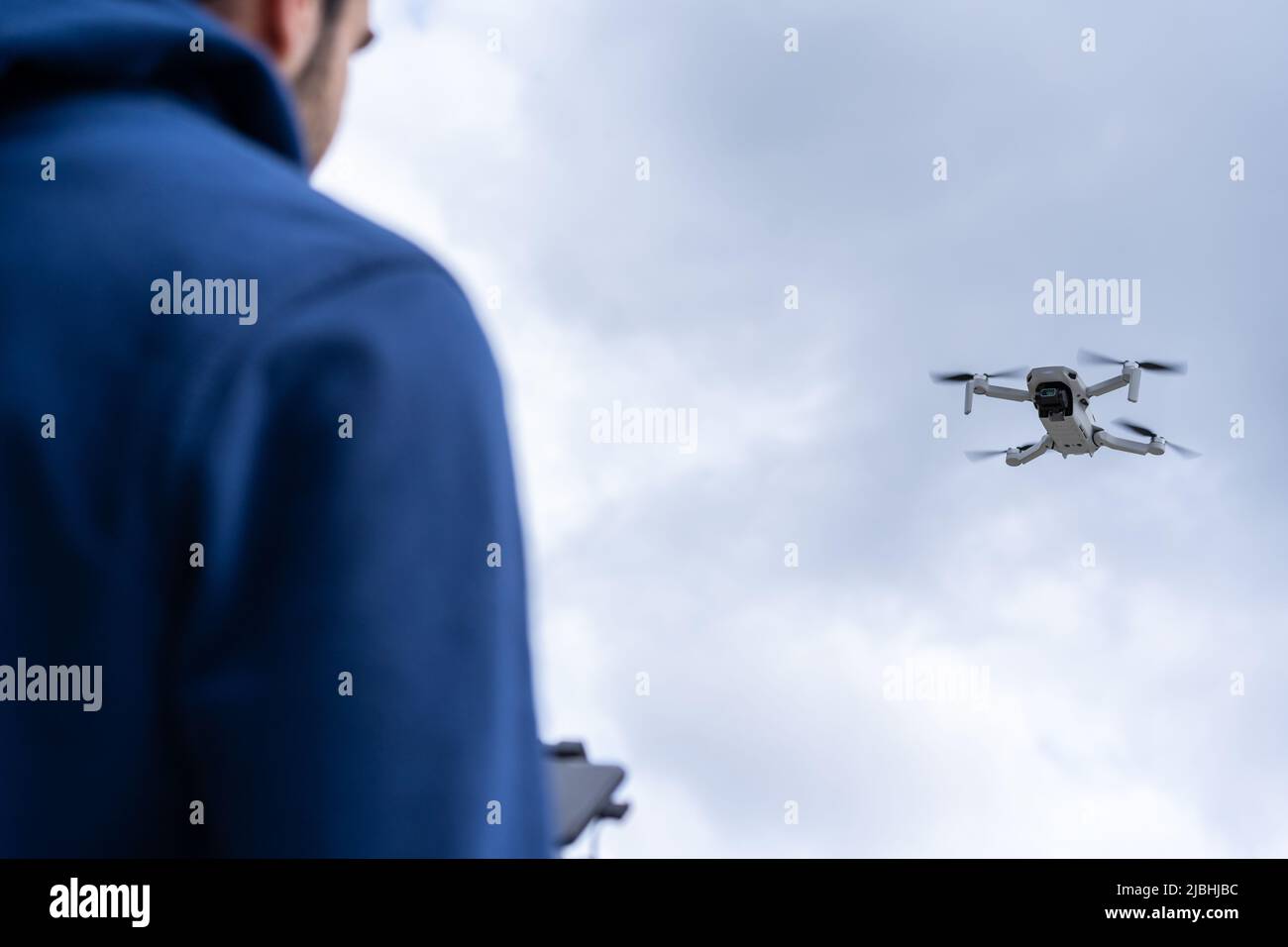 Young man with his back flying a drone outdoors Stock Photo - Alamy