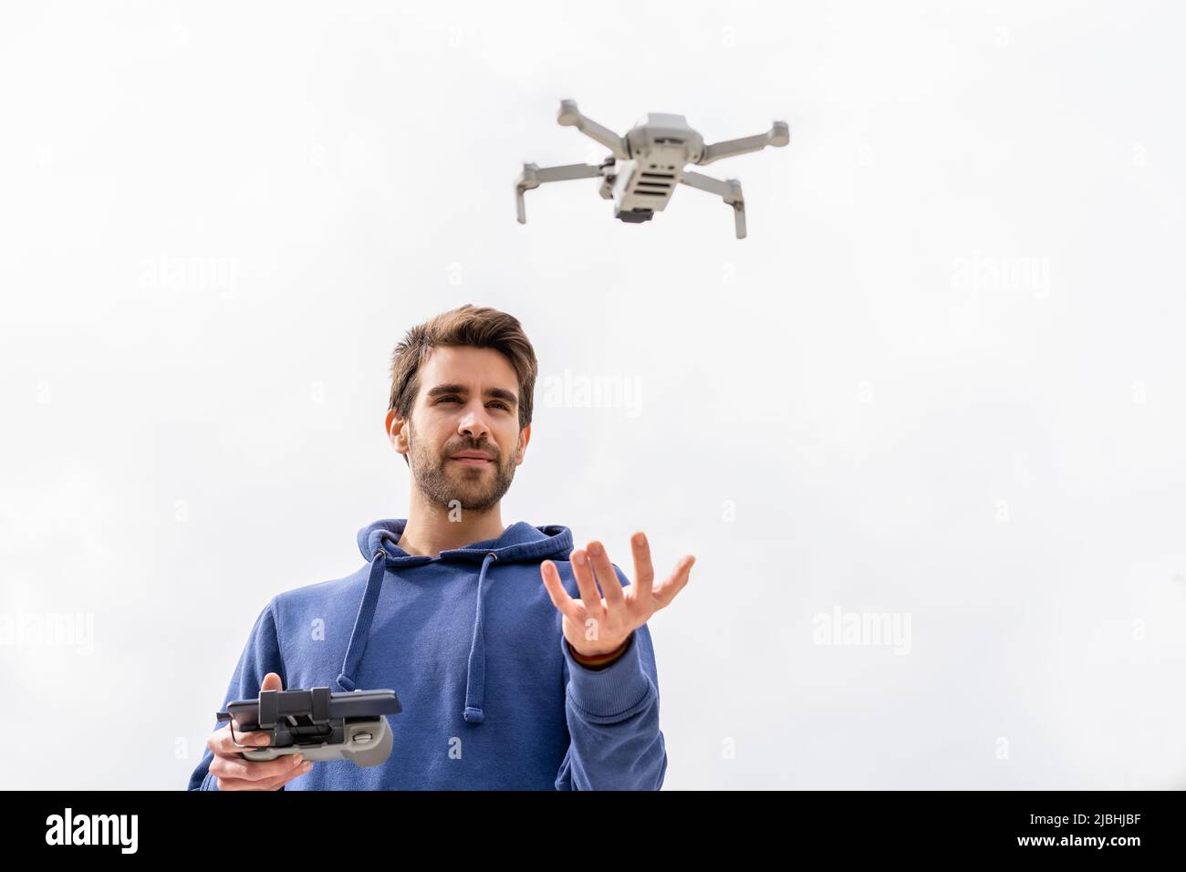 Young man operating a flying drone outdoors Stock Photo - Alamy