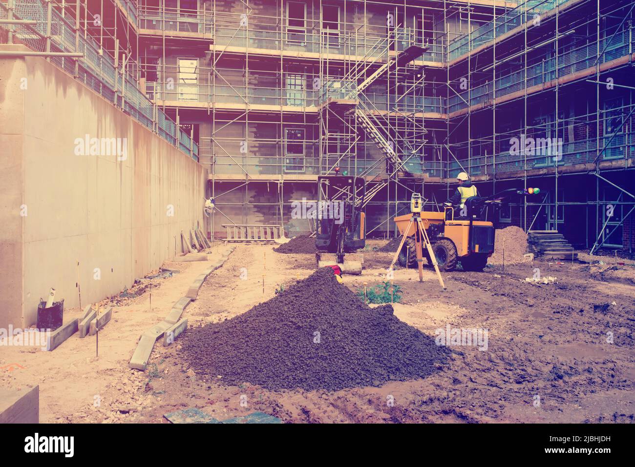 Builder driving dumper truck and excavator on new building construction ...