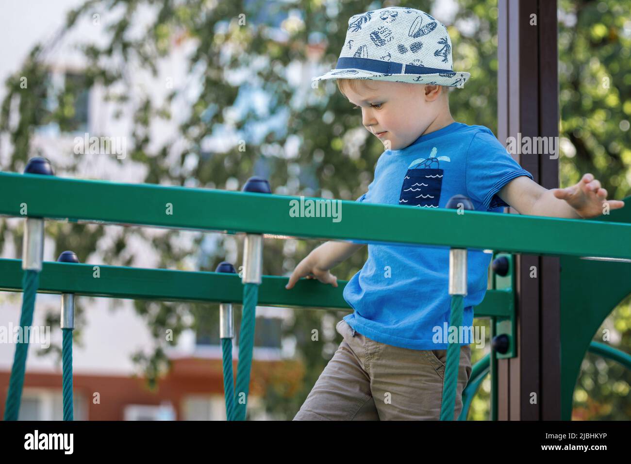 Boy on children playground in summer day. Sport for kids. The child ...